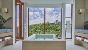 Um banheiro moderno com uma banheira grande, portas de madeira e vista para uma paisagem verde exuberante.