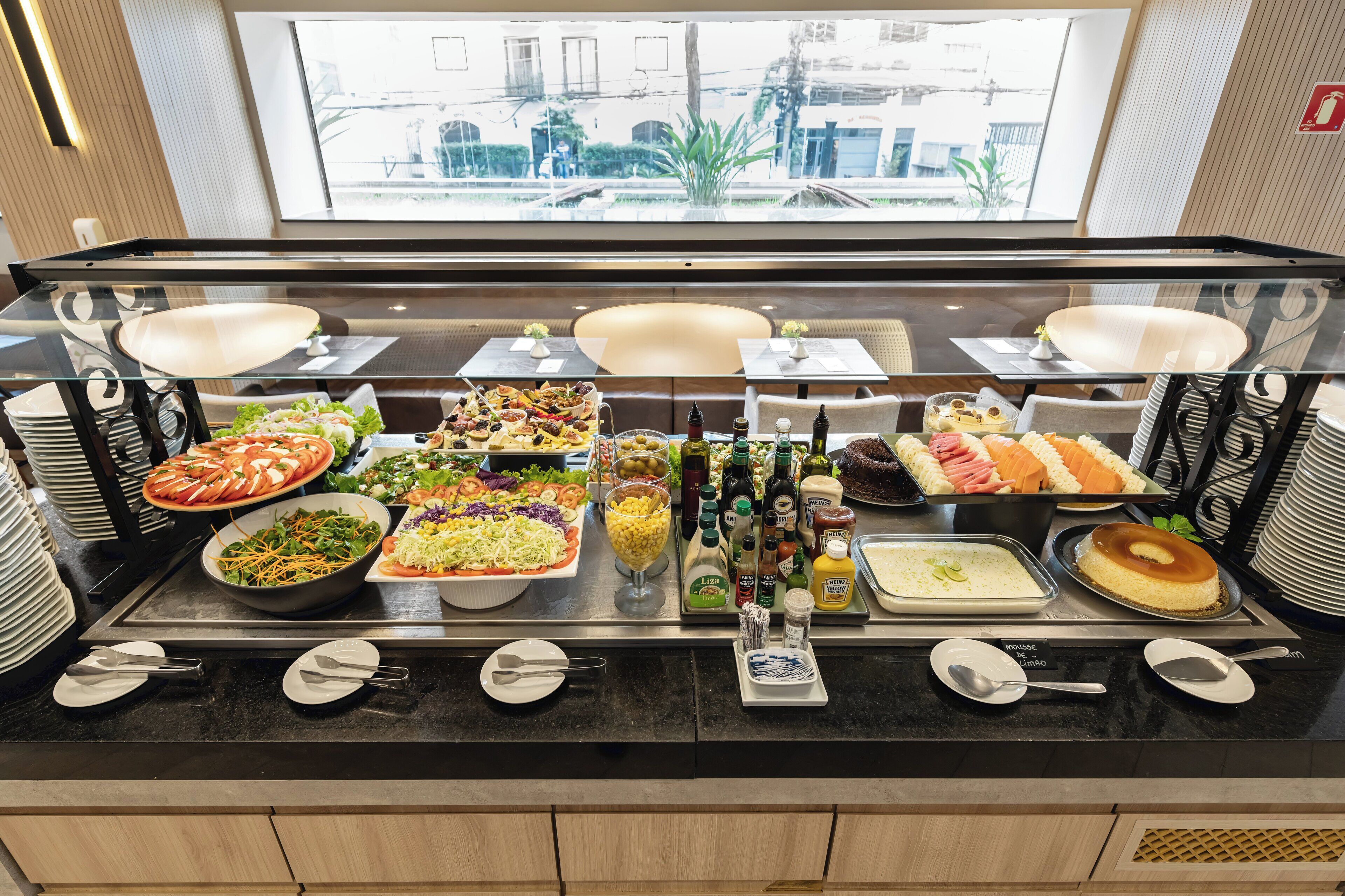 Um buffet com diversos pratos e acompanhamentos.