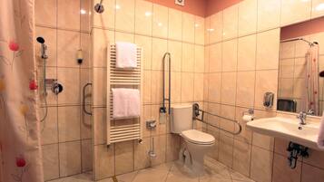 Casa de banho com sanita, lavatório, chuveiro e porta-toalhas.