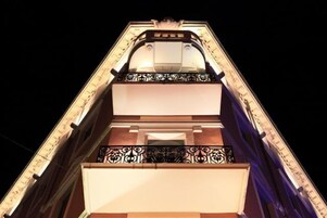 Um edifício com design escalonado, apresentando varandas com grades ornamentadas.