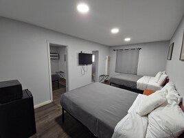 Quarto com duas camas, televisão e aquecedor.