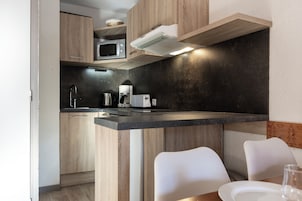 Um frigorífico, uma placa de cozinha, utensílios de cozinha 