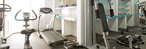 Uma academia com esteiras, elípticos e aparelhos de musculação.