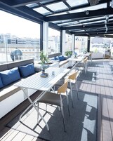 Terraço no telhado com área de estar externa, vista da cidade e design moderno.