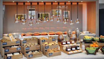 Buffet com diversos alimentos e um espelho.