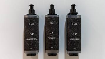 Três frascos de produtos TOI para o cabelo.