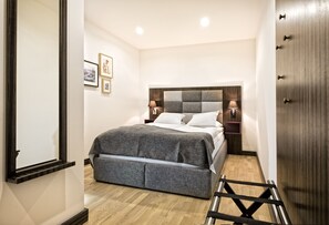Um quarto moderno com uma cama grande, abajures e quadros na parede.