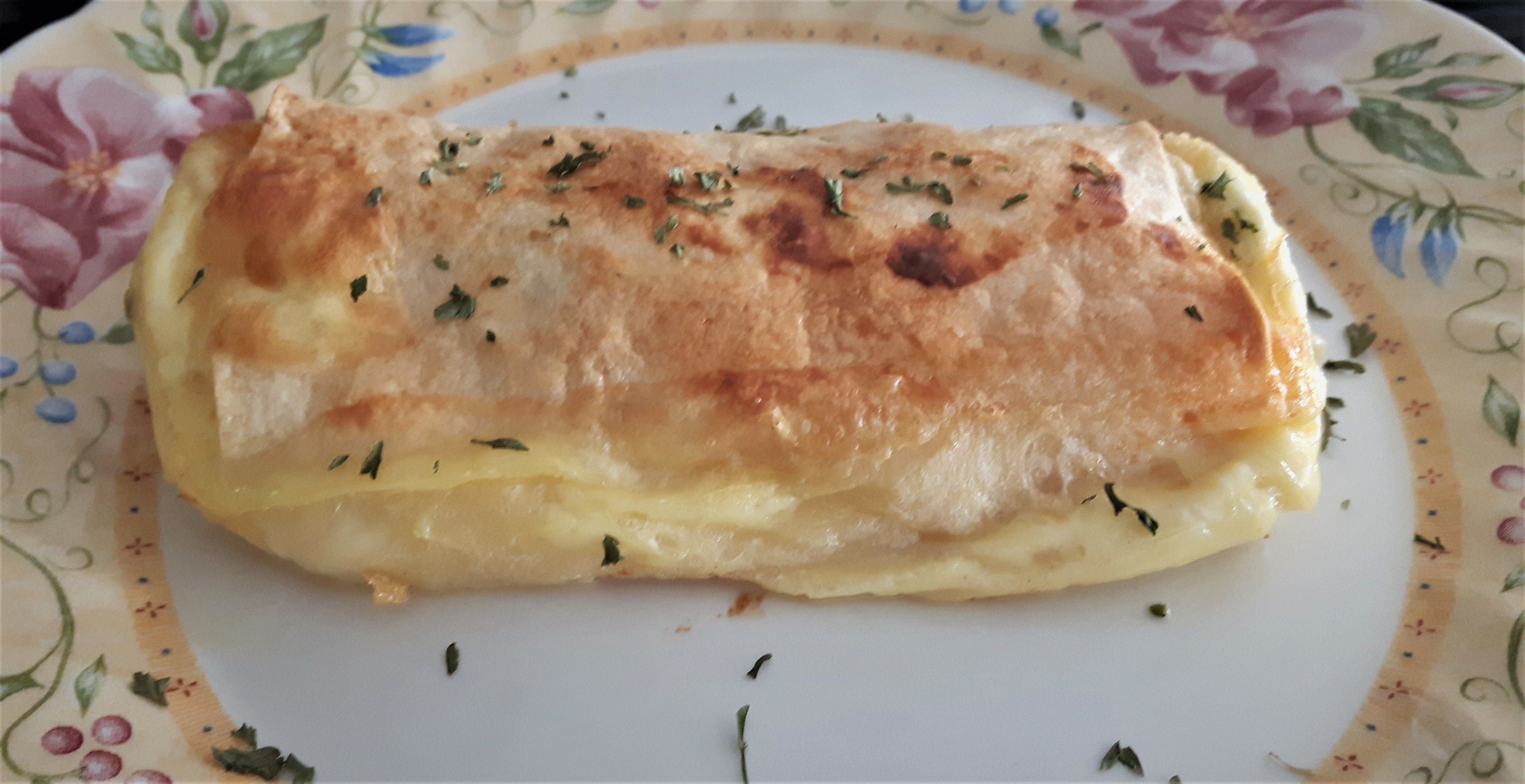 Um pastel dobrado num prato com padrão floral.