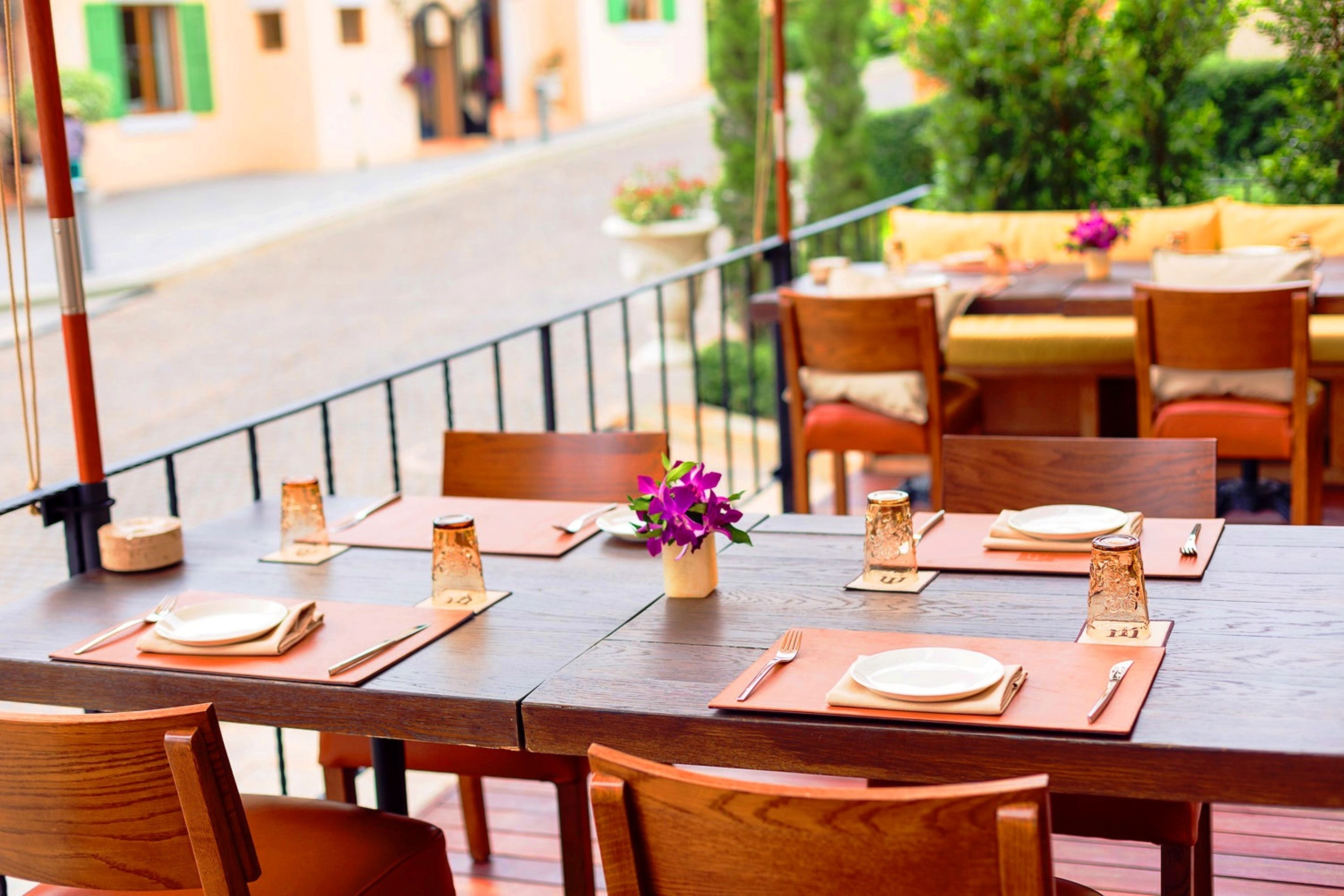 Um restaurante com mesas e cadeiras de madeira, disposto para refeições.