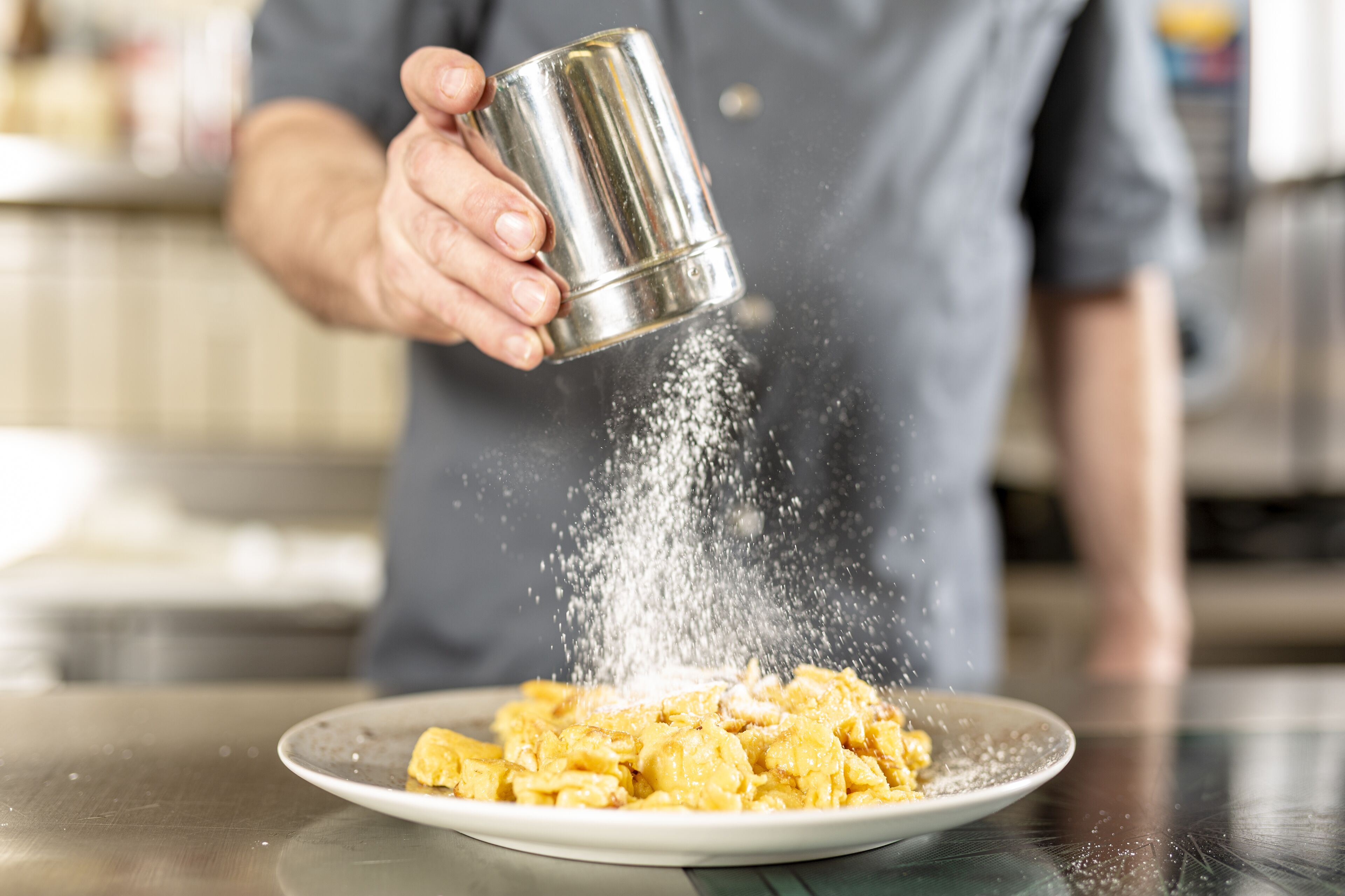 Alguém polvilhando sal sobre um prato de comida.