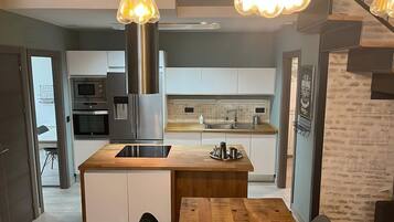 Um frigorífico/congelador grande, um micro-ondas, uma placa de cozinha