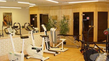 Uma academia com equipamentos de ginástica, um espelho e uma parede de madeira.
