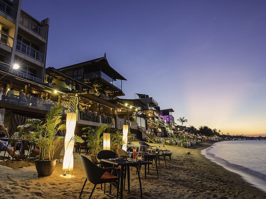 Na praia, espreguiçadeiras, guarda-sóis de praia, bares na praia