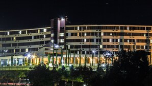 Um hotel de vários andares com design moderno, apresentando um átrio central e várias varandas.