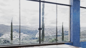 Uma área de spa com hidromassagem e vista para a paisagem urbana através de amplas janelas.