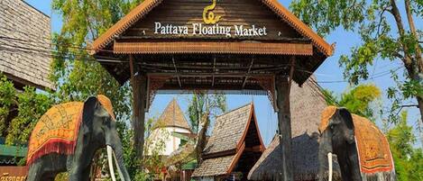 Entrada do Mercado Flutuante de Pattaya, com arquitetura tradicional tailandesa e duas estátuas de elefante.