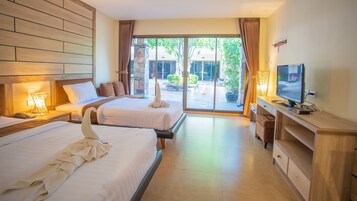 Quarto de hotel com duas camas, televisão e vista para a área externa.