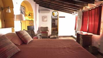 Um quarto com uma cama grande, uma cadeira, uma cômoda e um espelho.