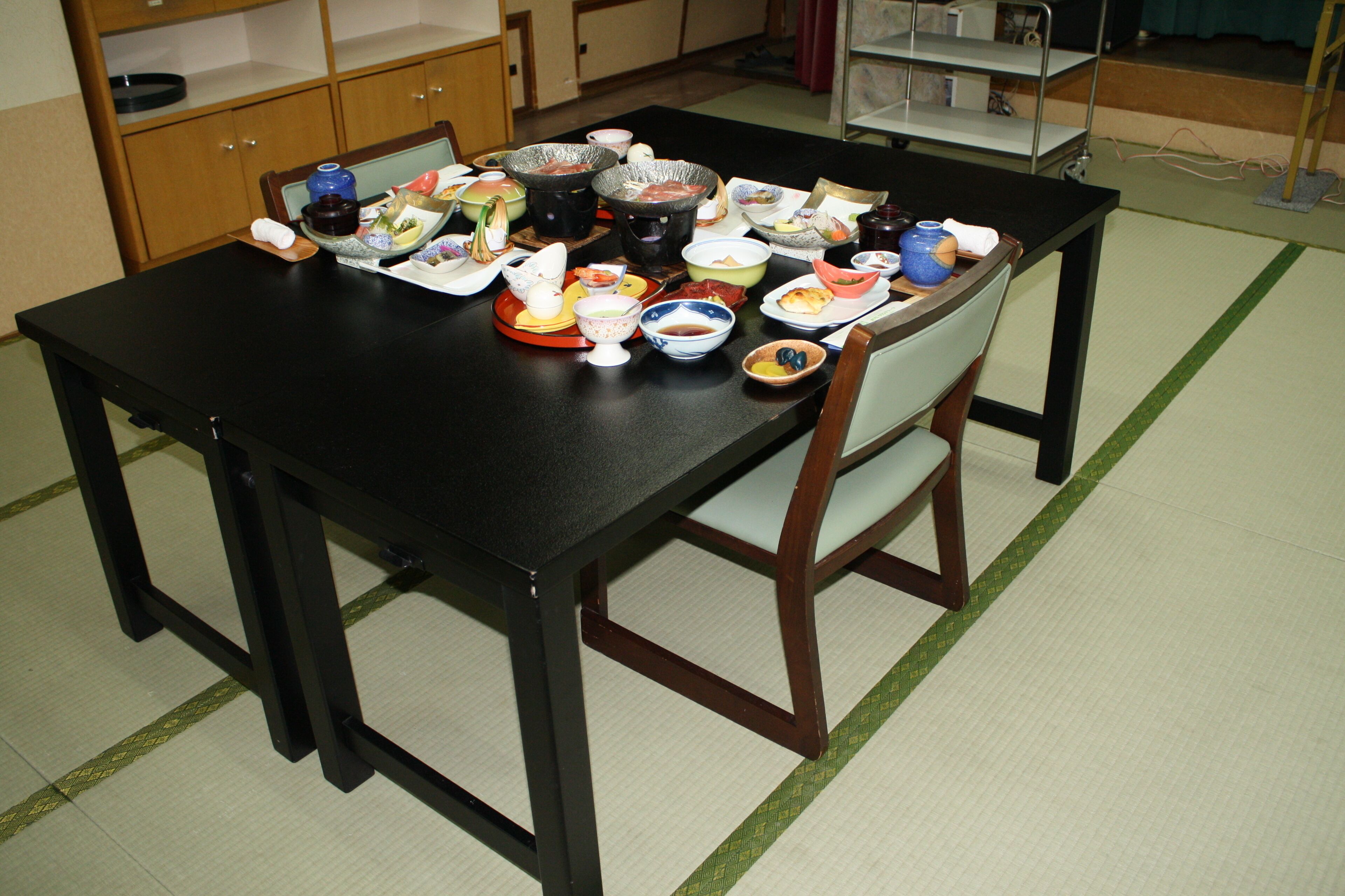 Uma mesa de jantar com diversos pratos e tigelas, rodeada por cadeiras.