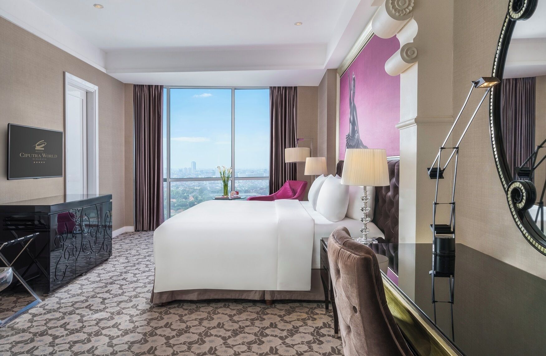 Quarto de hotel com uma cama grande, uma escrivaninha, uma cadeira, um espelho e vista para a cidade.