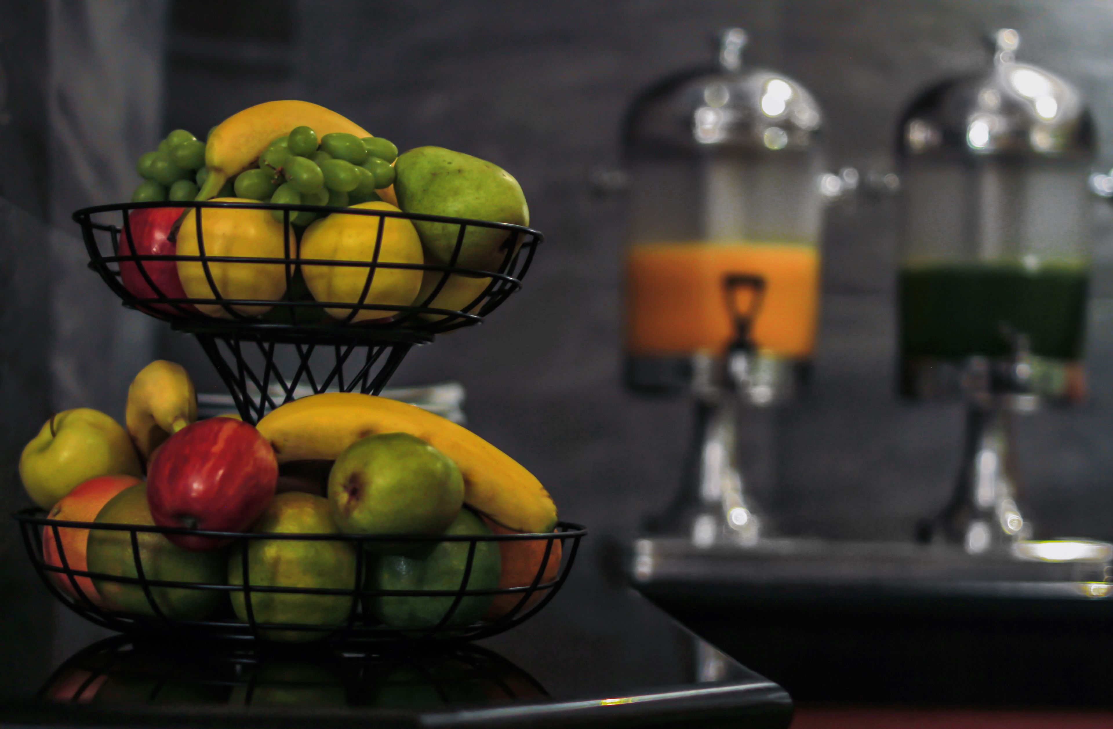 Uma cesta de frutas com maçãs e bananas sobre uma mesa.