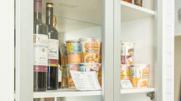 Um aparador com garrafas de Ballantine's e outras bebidas, pacotes de petiscos e um menu.