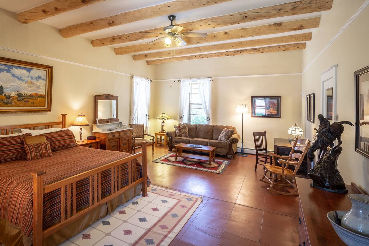 Um quarto espaçoso com uma cama grande, teto de madeira e um quadro na parede.