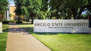 Placa da Angelo State University com um caminho que leva à entrada.