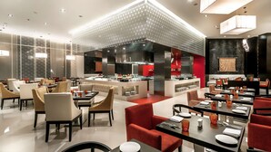 Um restaurante moderno com um balcão central, várias mesas de jantar e um design de interiores contemporâneo.