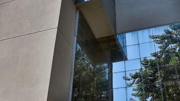Um edifício moderno com fachada de vidro destacada e design geométrico.