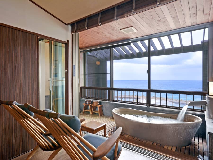 Um secador de cabelo, chinelos, sanita com bidé eletrónico