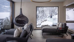 Uma sala de estar moderna com uma janela grande, um lustre e um sofá.