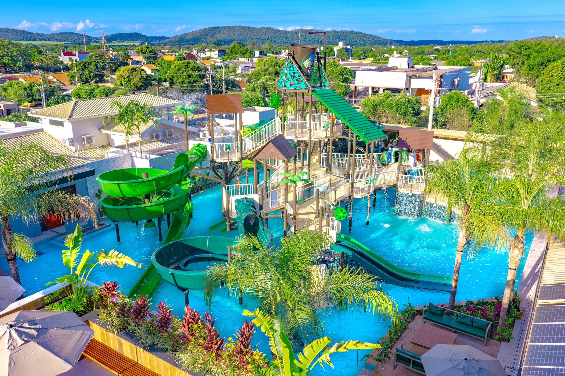 Um resort com uma piscina grande, toboáguas e vista da região ao redor.