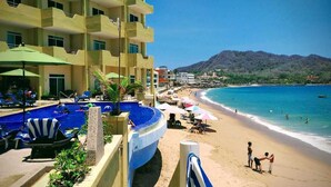 Um hotel com área de piscina, acesso à praia e vista para o oceano.