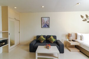 Uma sala de estar moderna com um sofá, uma mesa de centro, uma televisão e uma cama.