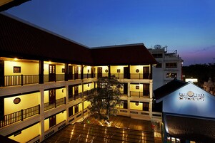 Um hotel de vários andares com arquitetura tradicional, apresentando varandas e um pátio.