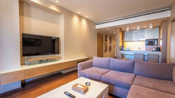 Uma sala de estar moderna com televisão de tela plana, um sofá e uma mesa de centro.