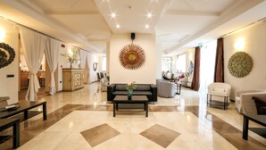Um hall amplo com uma mesa de centro, área de estar e arte decorativa na parede.