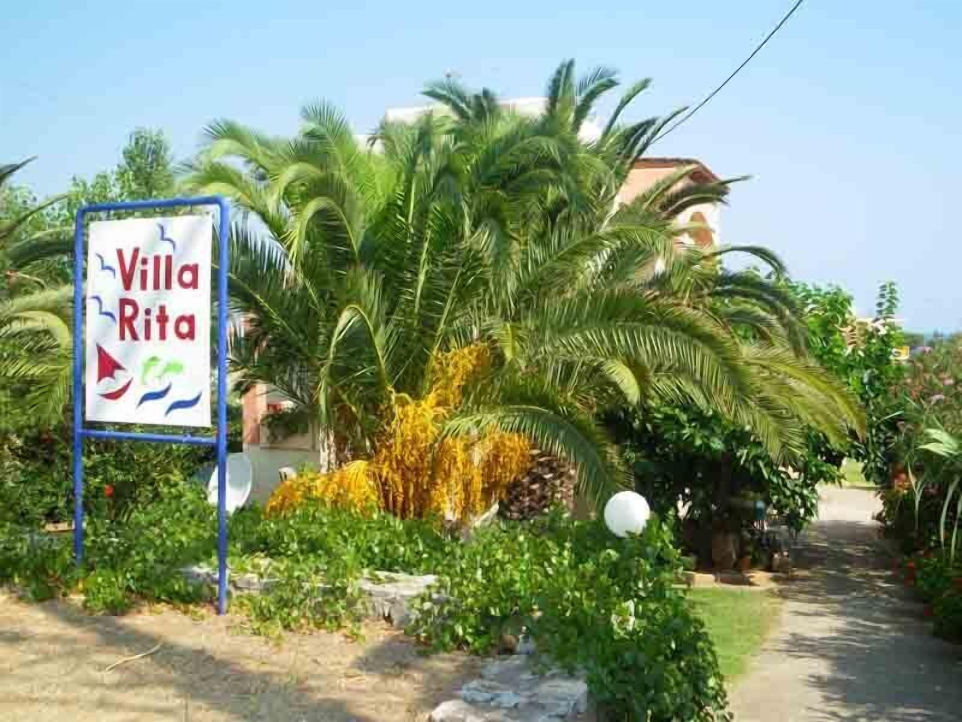 Placa de Villa Rita, com um jardim tropical ao fundo.