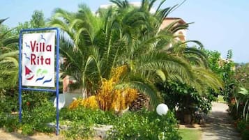 Placa de Villa Rita, com um jardim tropical ao fundo.