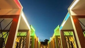 Um edifício moderno com um corredor central ladeado por duas alas, cada uma com um esquema de cores diferente.