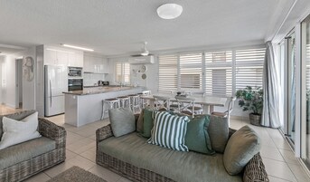 Uma sala de estar moderna com um sofá, uma mesa de jantar e uma cozinha.