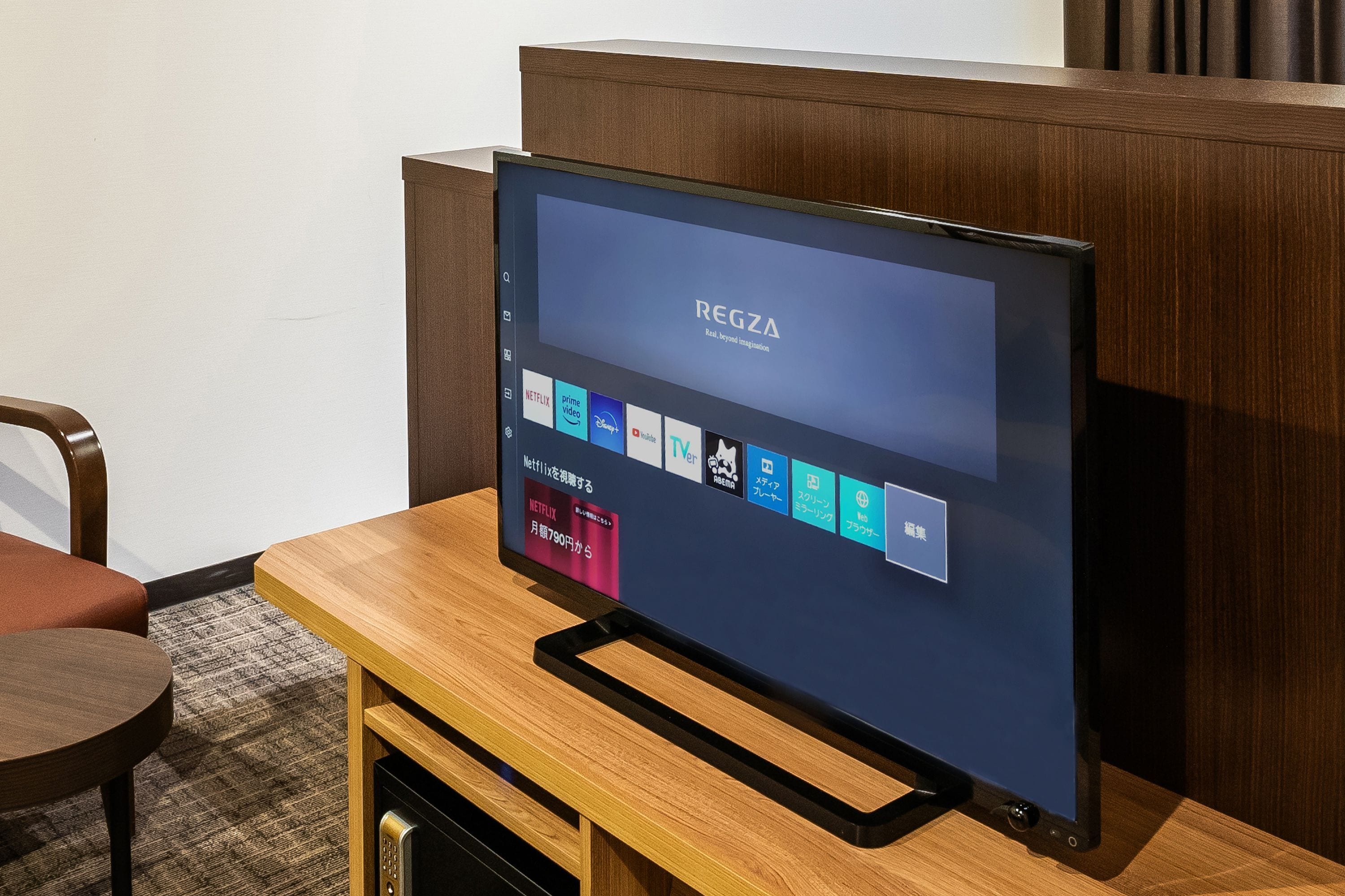 Uma televisão exibindo uma interface de serviço de streaming com vários ícones de aplicativos e uma mensagem promocional da Netflix.