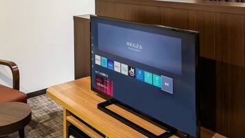 Uma televisão exibindo uma interface de serviço de streaming com vários ícones de aplicativos e uma mensagem promocional da Netflix.