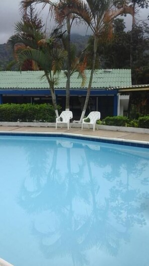 Piscina externa, piscina com cascata, espreguiçadeiras