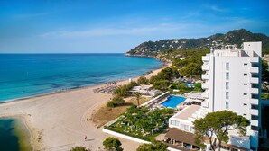 Um resort à beira-mar com piscina, espreguiçadeiras e vista para o oceano.