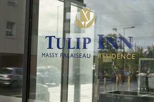 Uma janela com o texto "TULIP INN MASSY PALAISEAU - RESIDENCE".