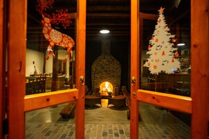 Um interior acolhedor com lareira de pedra, mobiliário de madeira e decorações festivas.