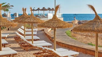 Perto da praia, espreguiçadeiras, guarda-sóis, toalhas de praia