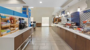 Uma cozinha moderna com bancada comprida, vários eletrodomésticos e um menu em lousa.